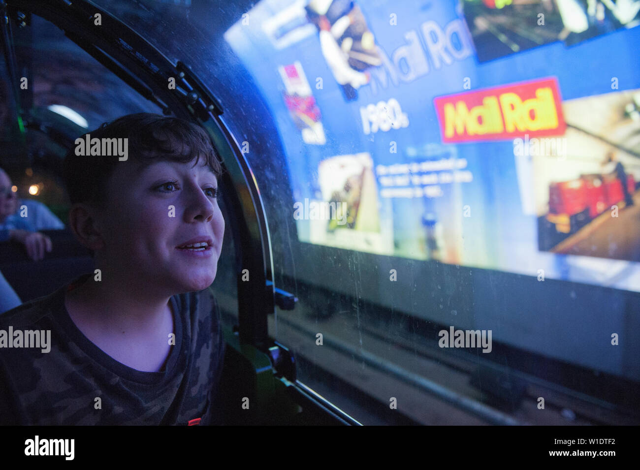 Teenager riding on the Mail Rail train at the postal museum, London ...