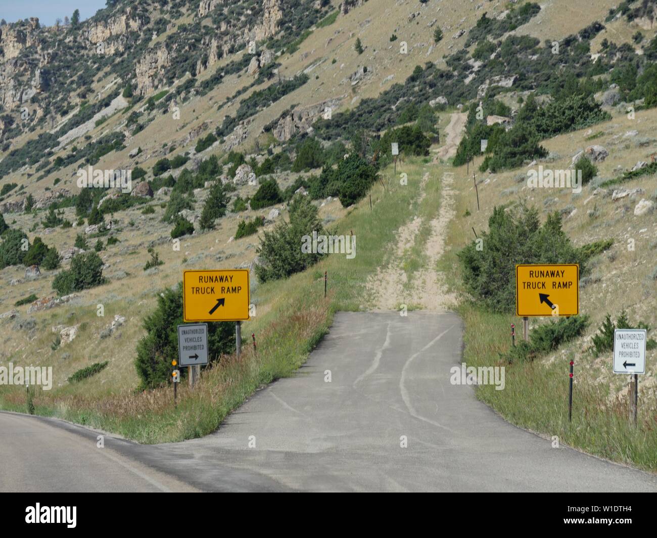 Medium wide shot of a runway truck ramp on a cliffside to help prevent ...