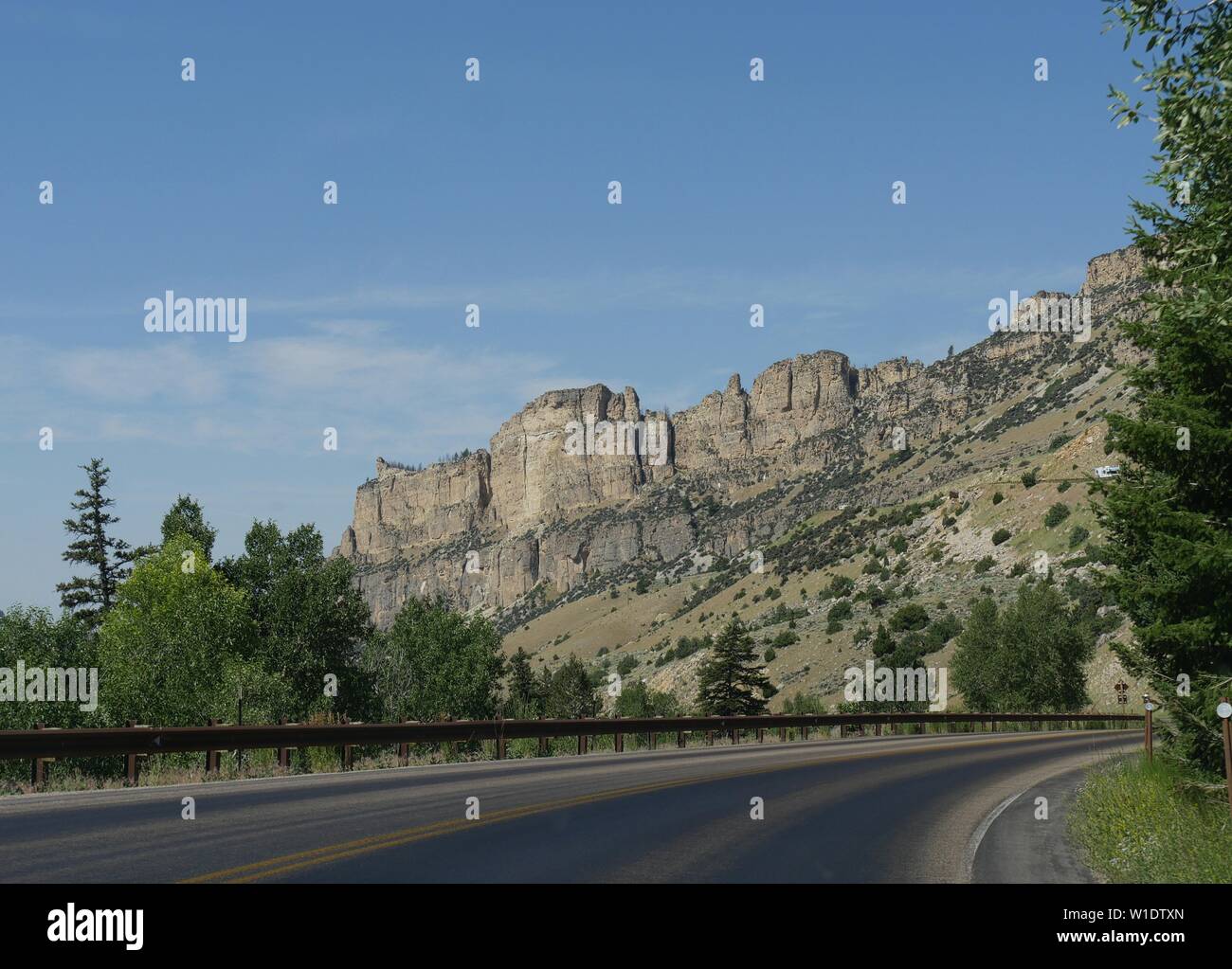 Dramatic granite cliffs and rock formations along a winding road at ...
