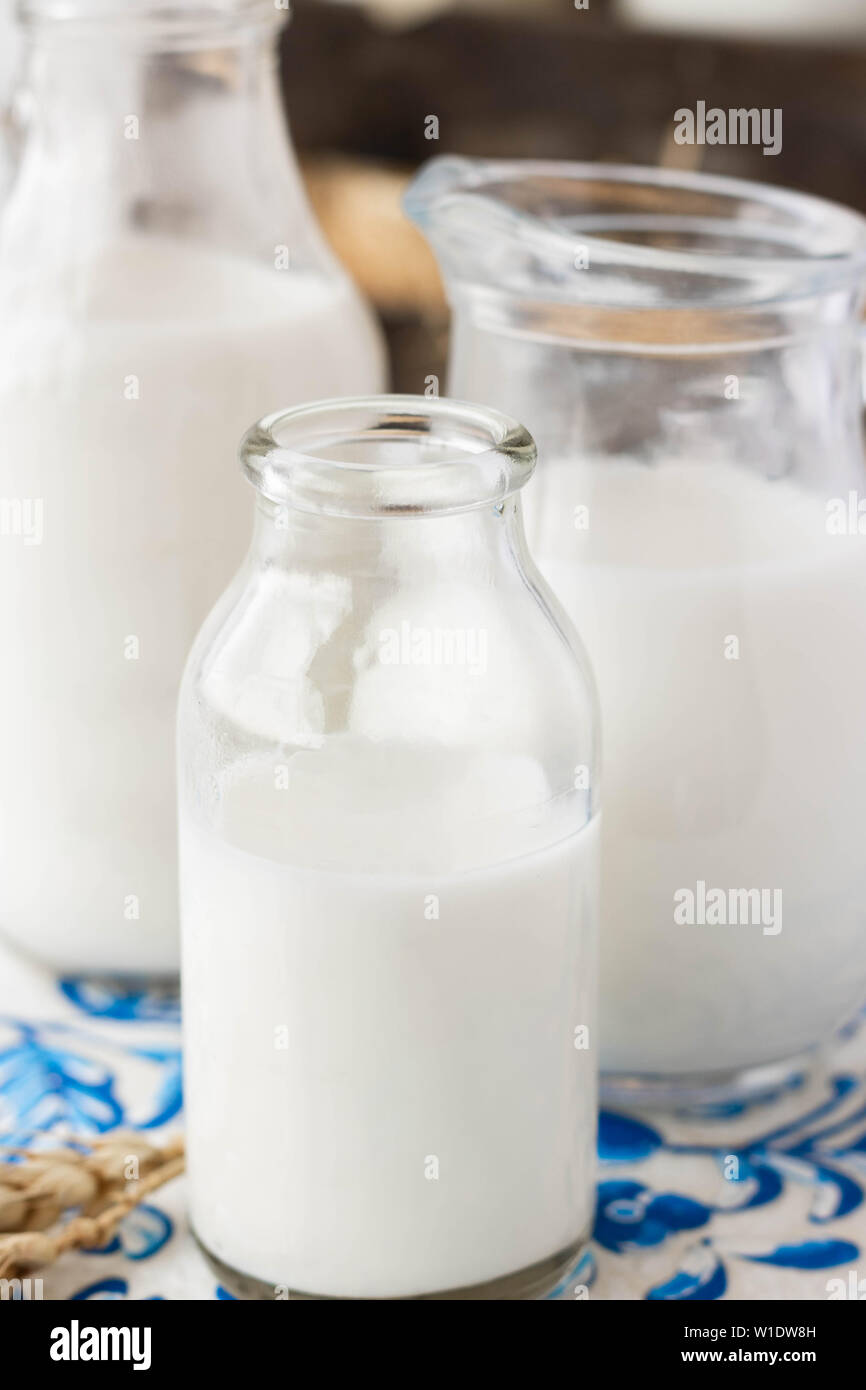 Bottles of milk of various shapes and sizes on a light background Stock ...