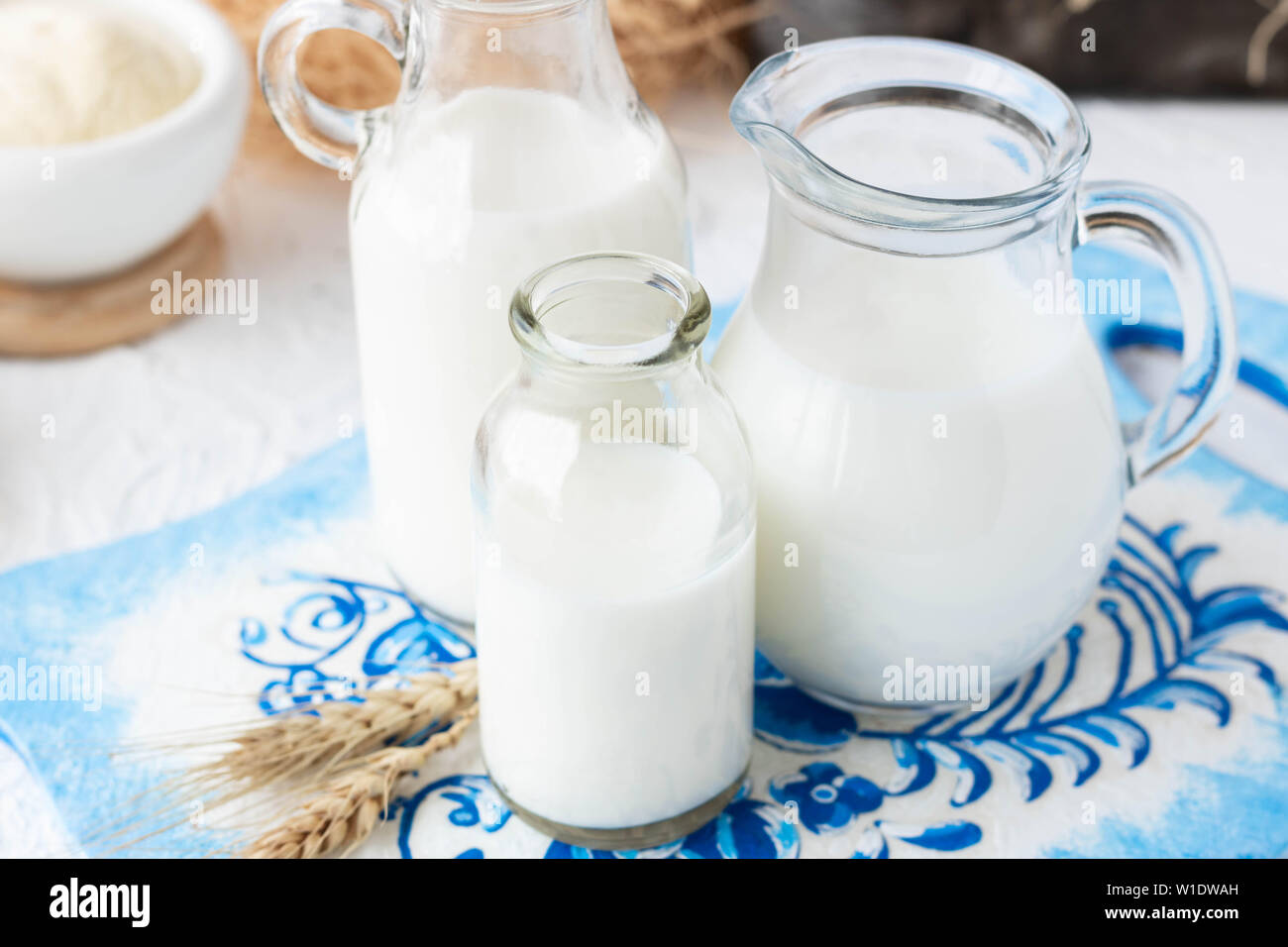 Bottles of milk of various shapes and sizes on a light background Stock ...