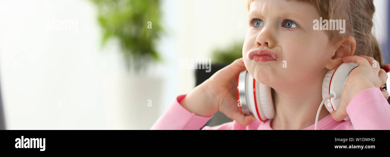Little girl wearing headphones using computer aggressive articulating ...