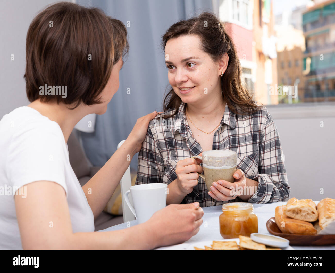 Two woman friends talking and drinking tea in the kitchen Stock Photo ...