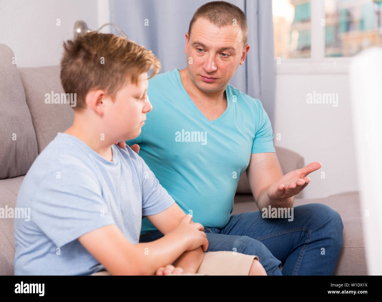 Sad guy with his father are resting and talking about teenage life at ...