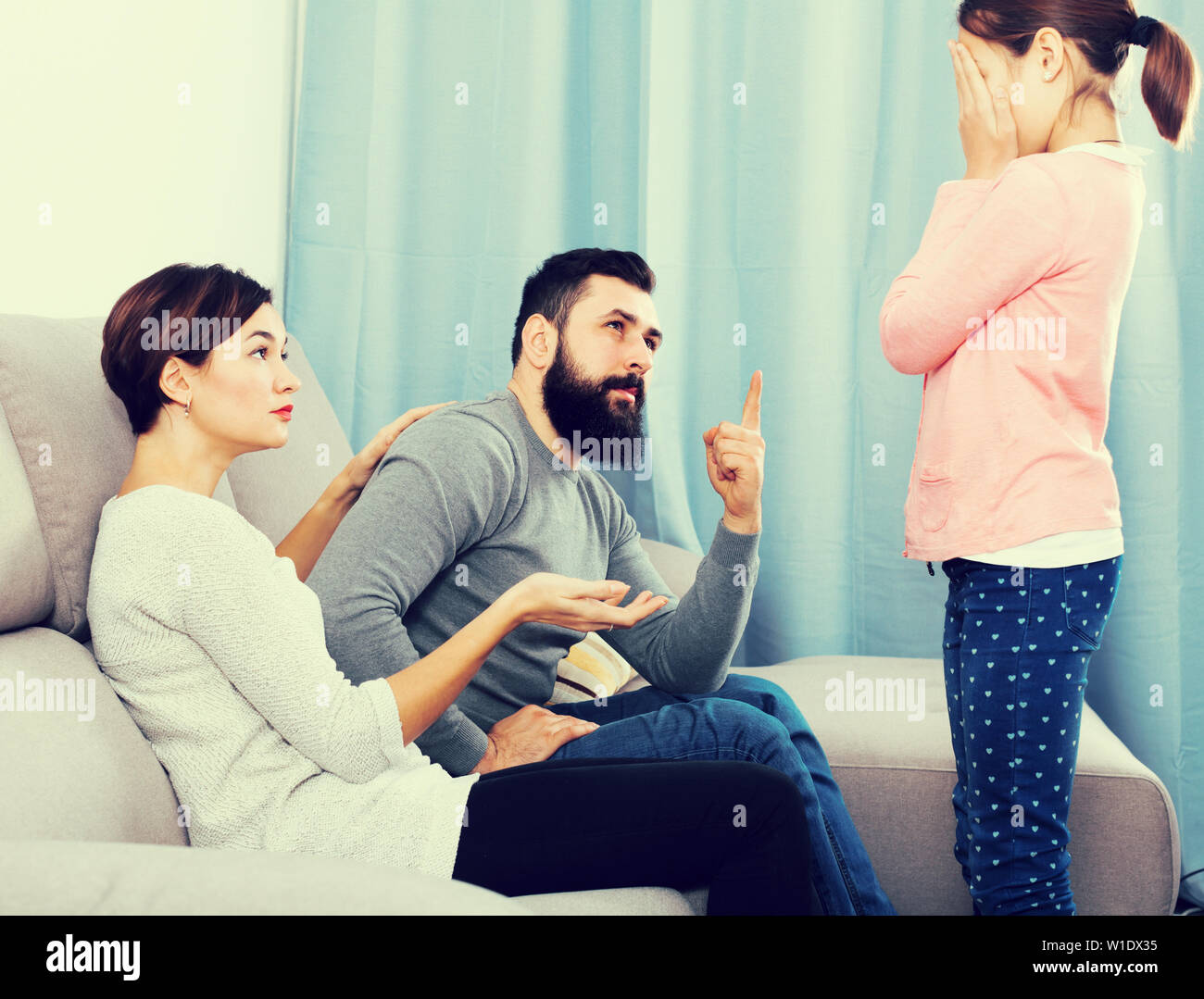 Young parents rebuking their daughter for bad behavior at home Stock ...