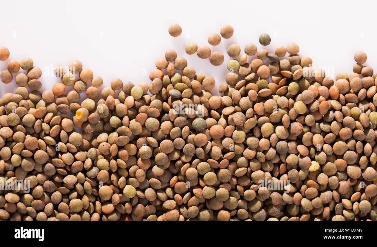 Natural background of lentils seeds on white surface, organic food ...