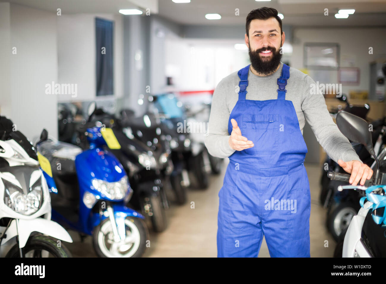 vigorous man worker displaying various motorcycles in motorcycle ...