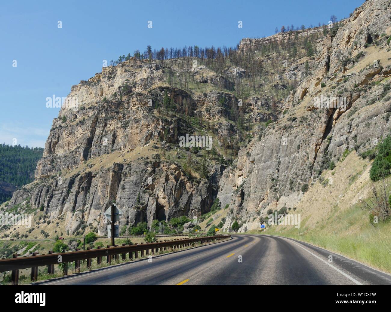 Stunning rock walls and geologic formations along a winding road ...