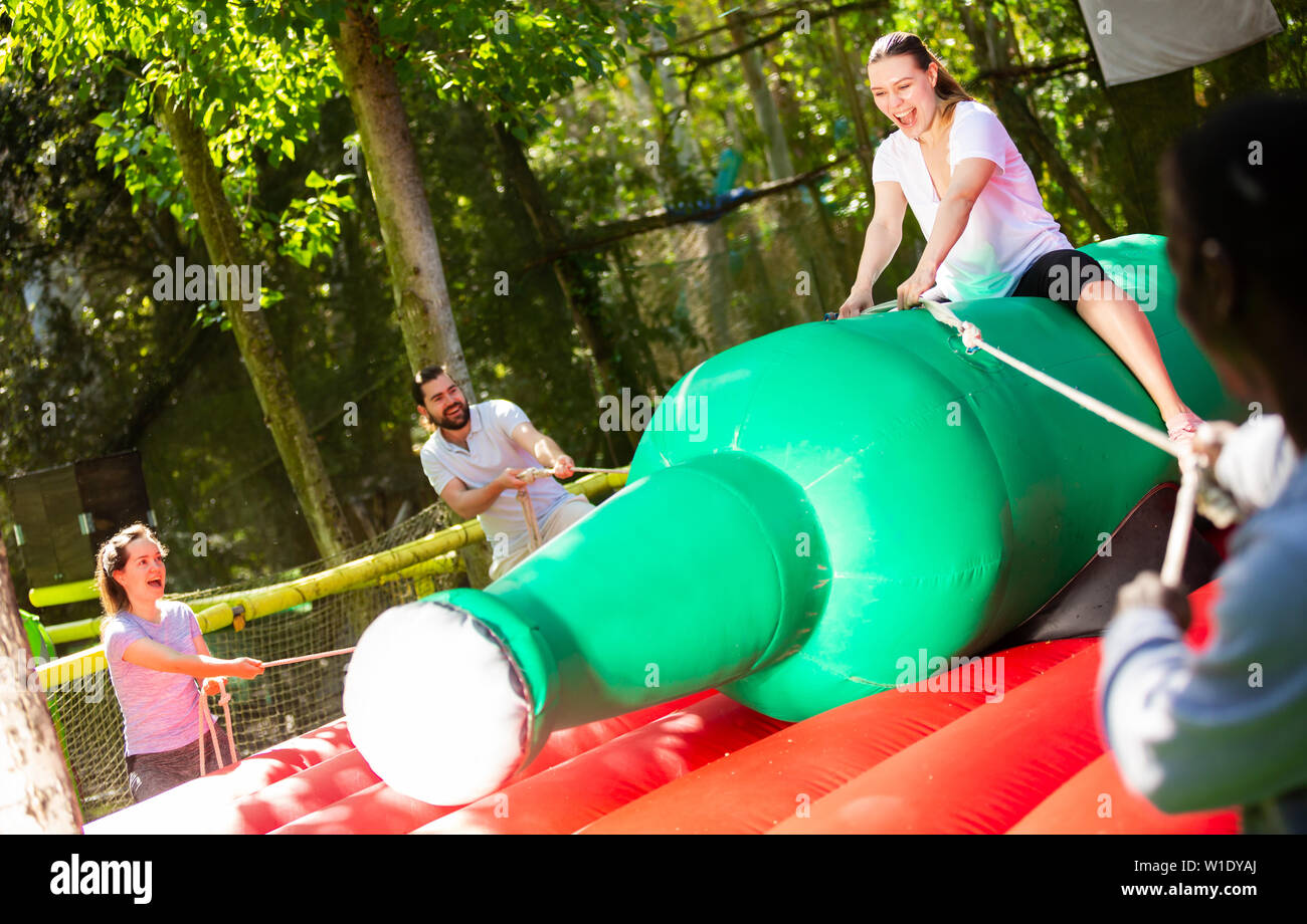 Fun attraction - woman trying to stay on an inflatable bottle Stock ...