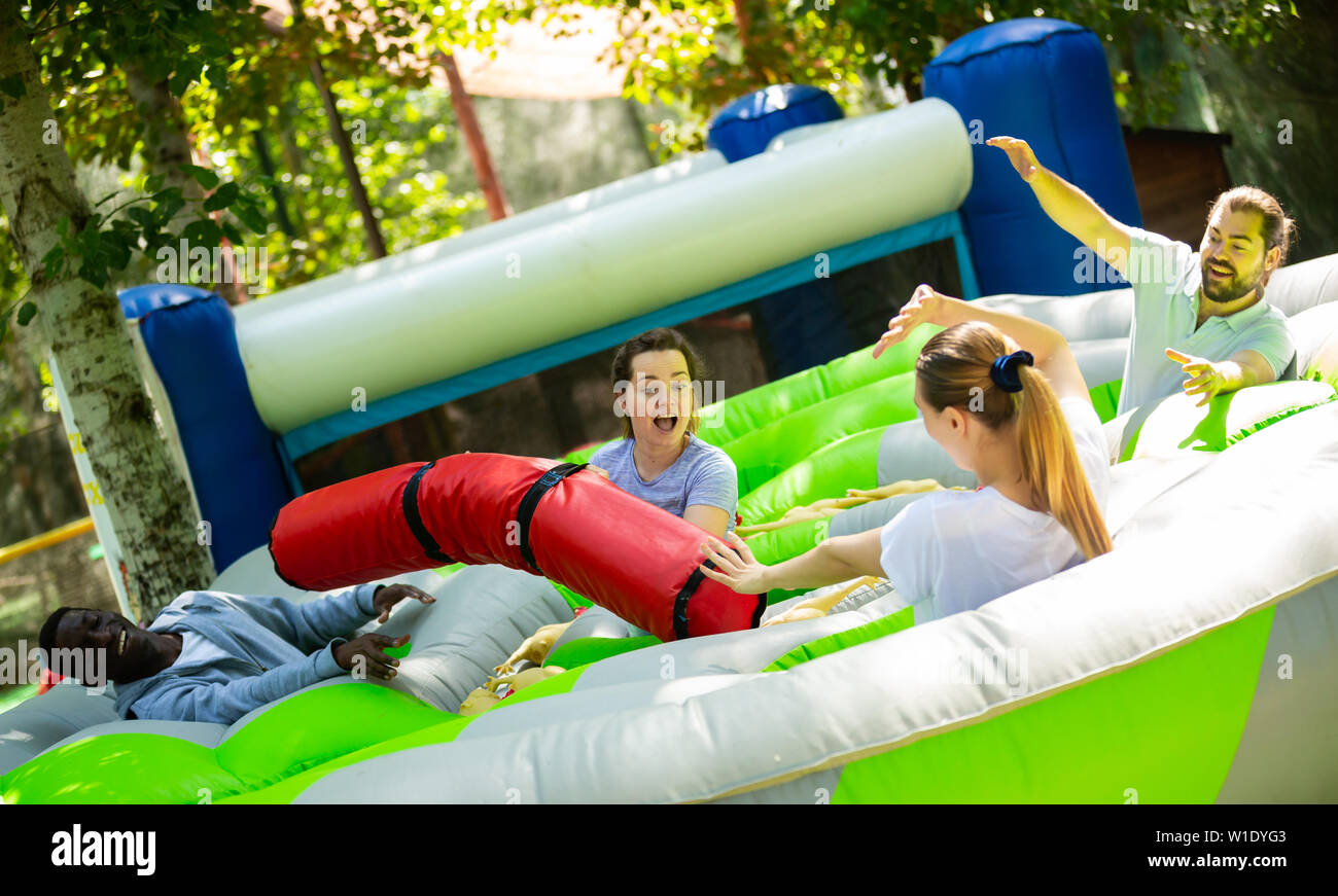 Team of friends playing with inflatable sticks on the trampoline Stock ...