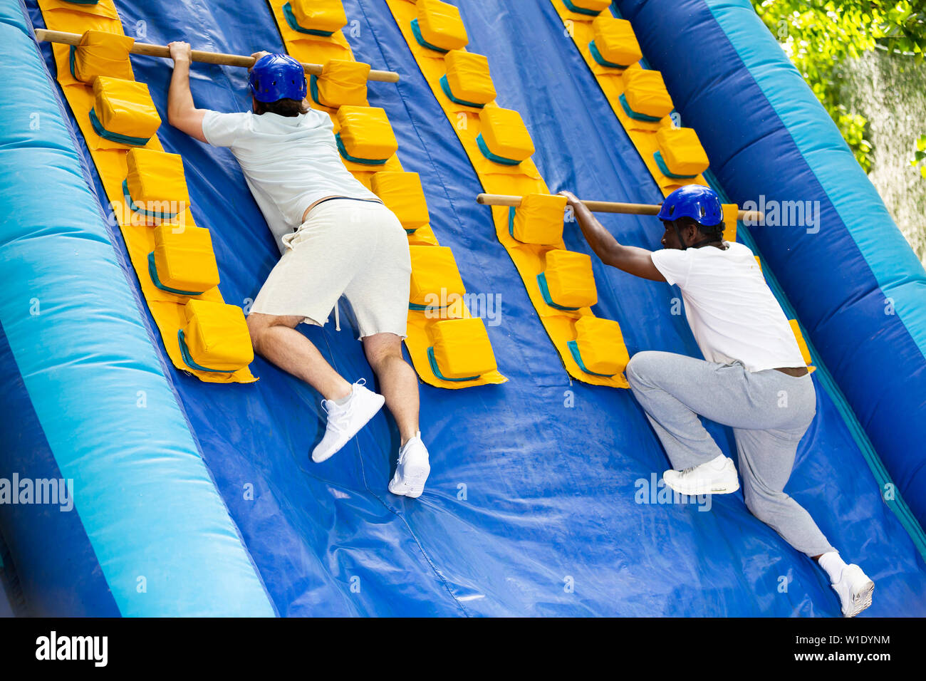 Mens competition on an inflatable slide Great race in an amusement park ...