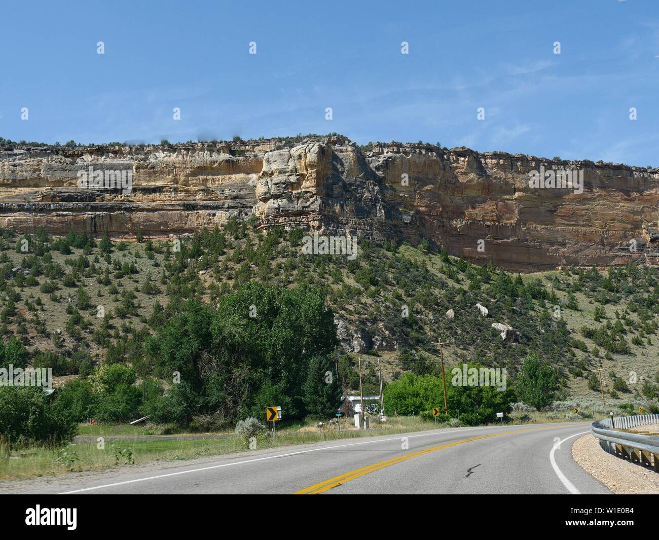 Closer view of high rocky walls and geologic formations along a winding ...