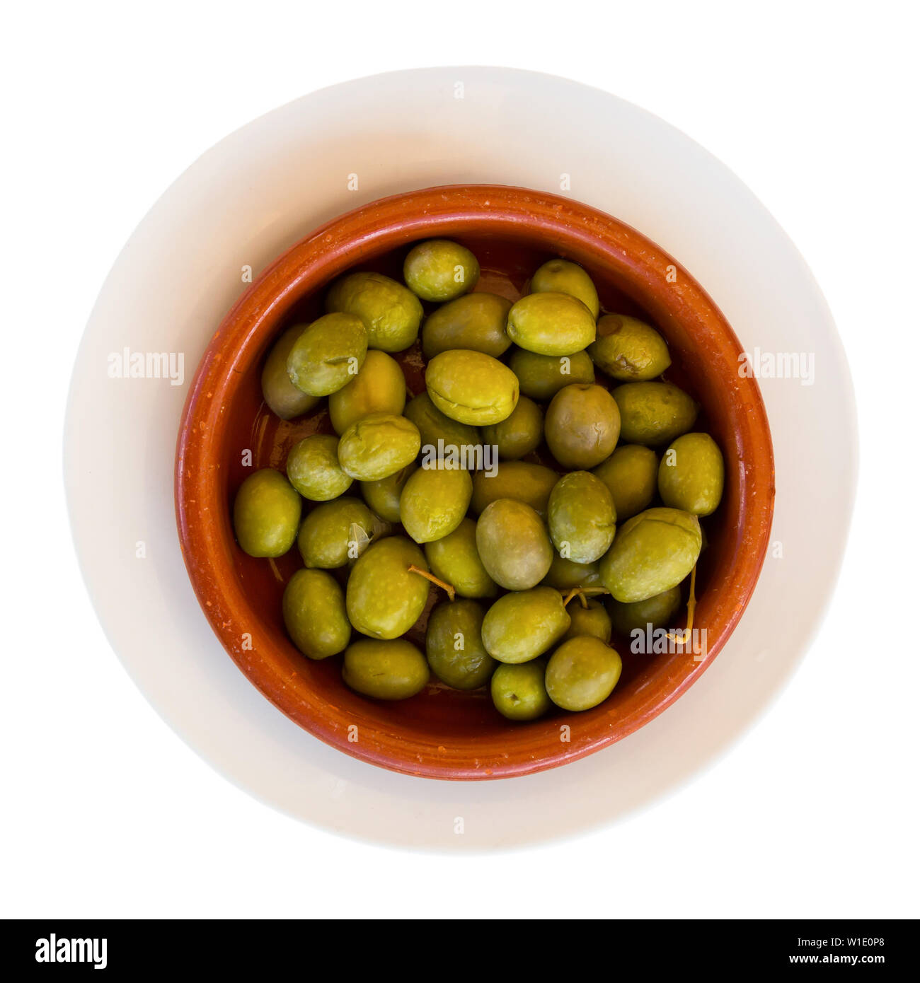 Green olives in clay bowl – Spanish tapas. Isolated over white ...