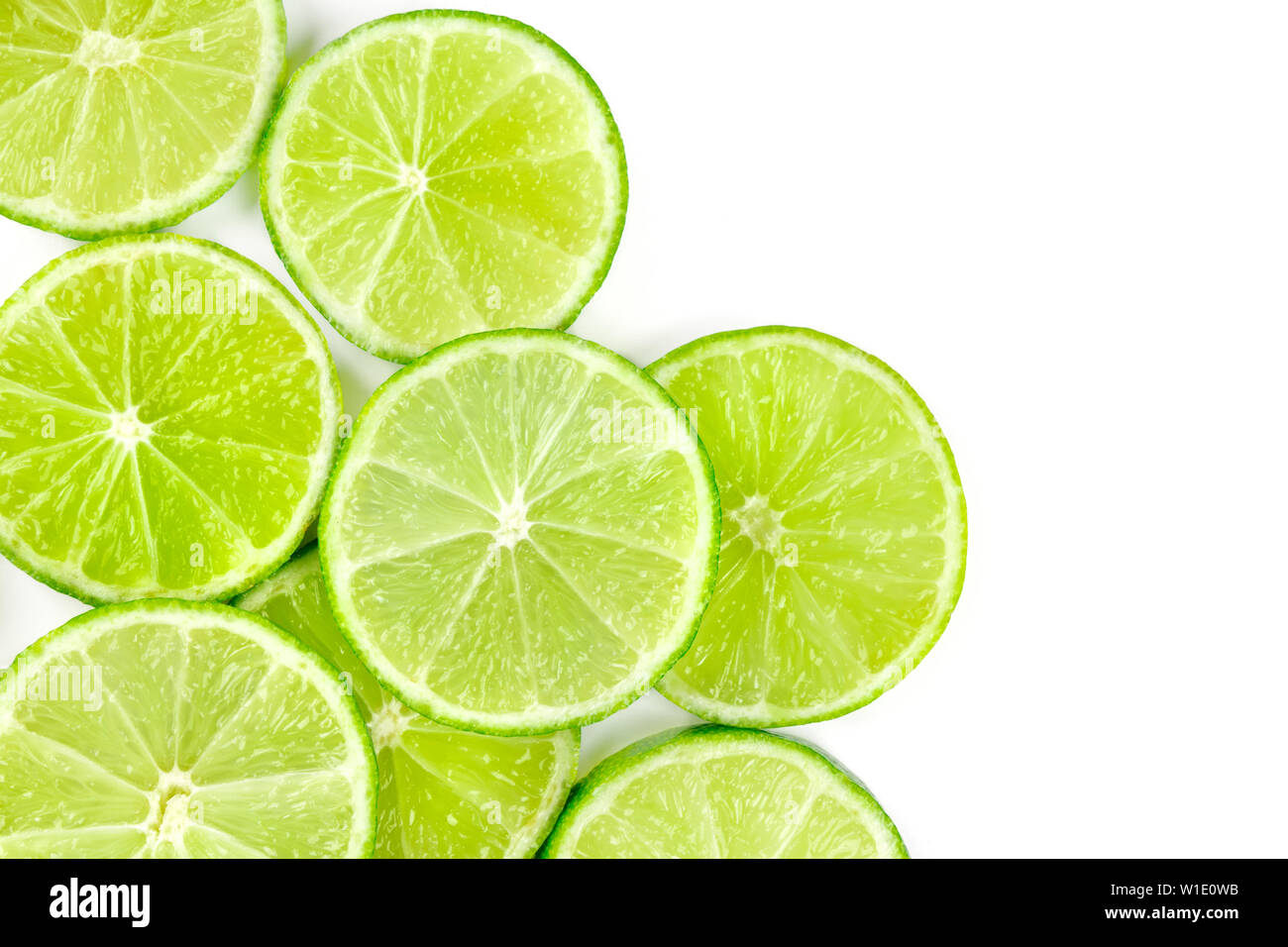 Vibrant lime slices, shot from above on a white background with copy ...