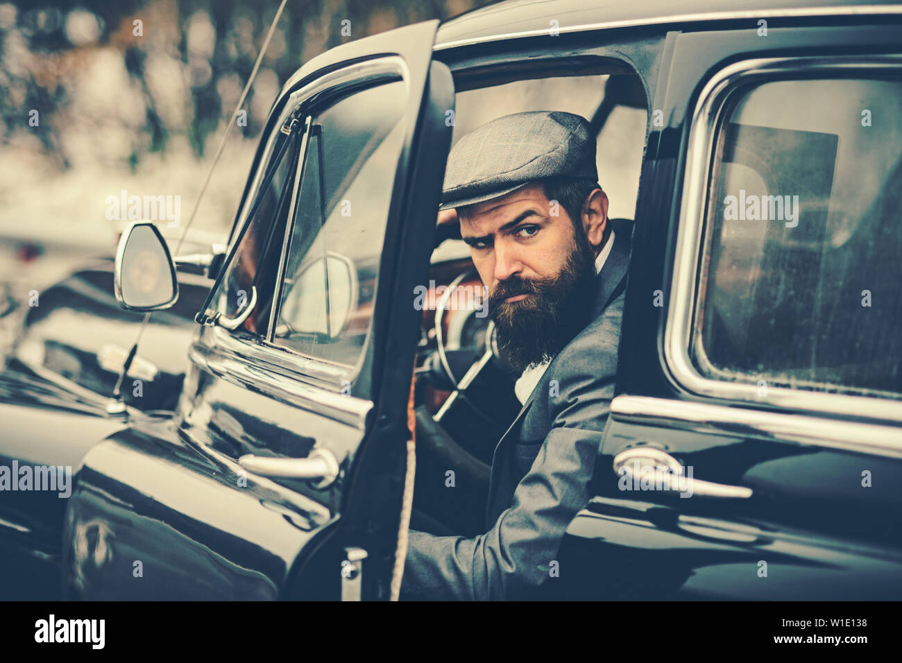 Confident wealthy young man with beard in classic car Stock Photo - Alamy