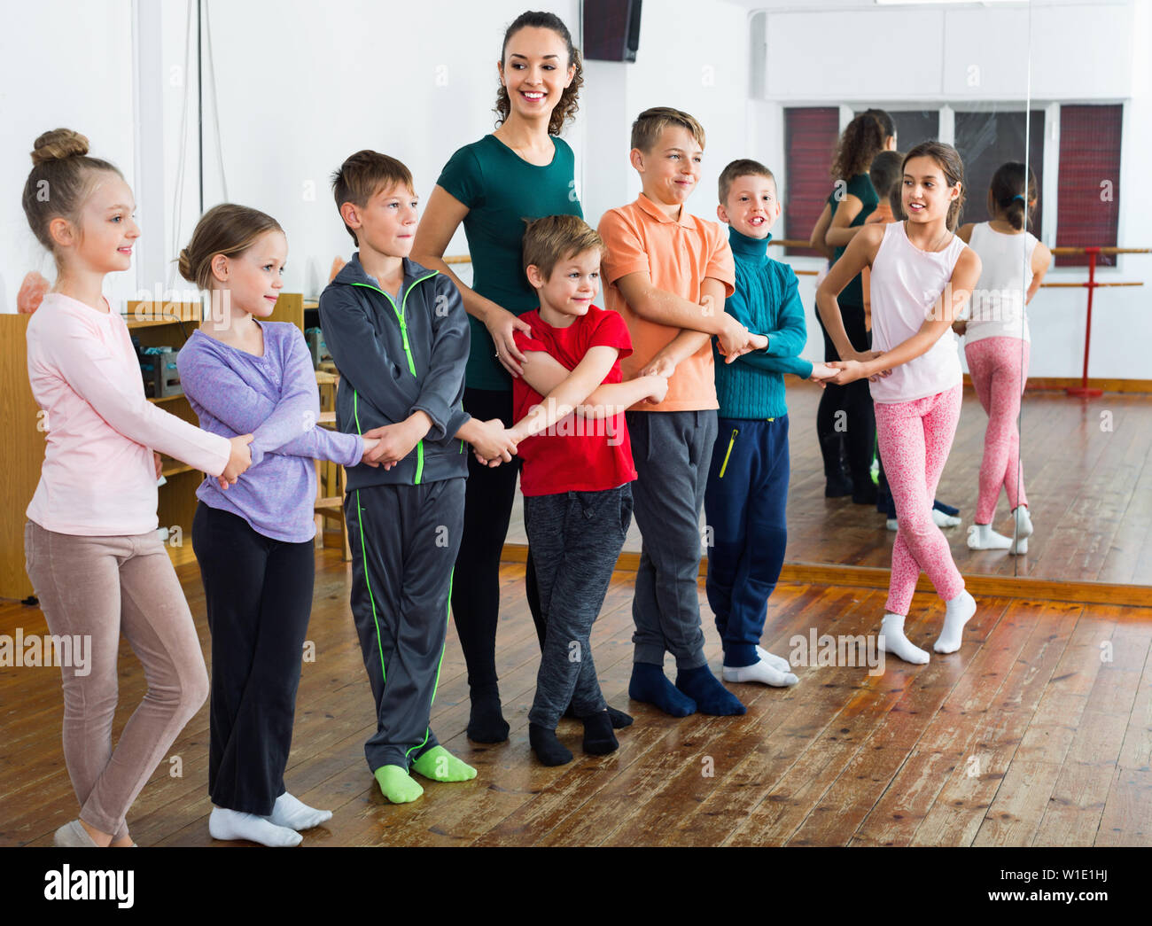 Happy positive children dancing folk dance in studio smiling and having ...