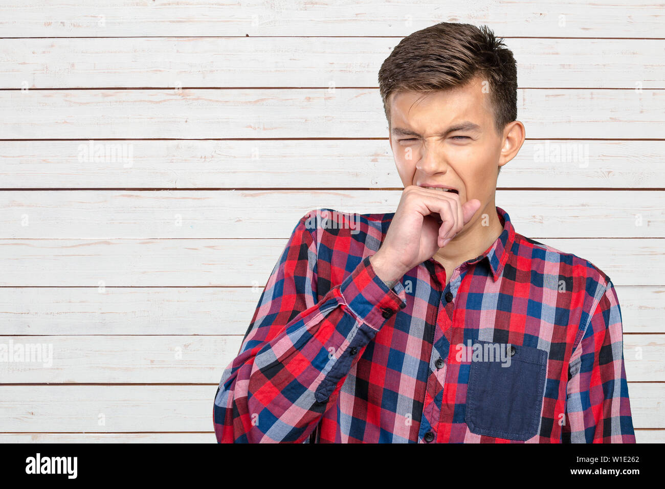 Tired young man yawning Stock Photo - Alamy