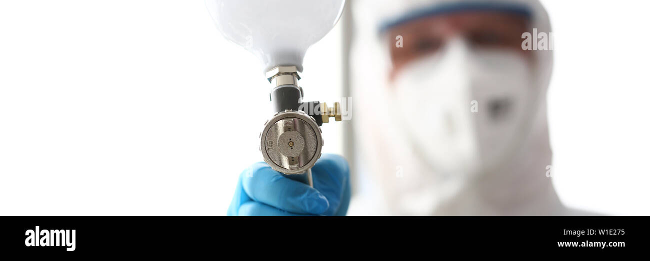 Workman hold in hand sprayer wearing protective suit Stock Photo - Alamy