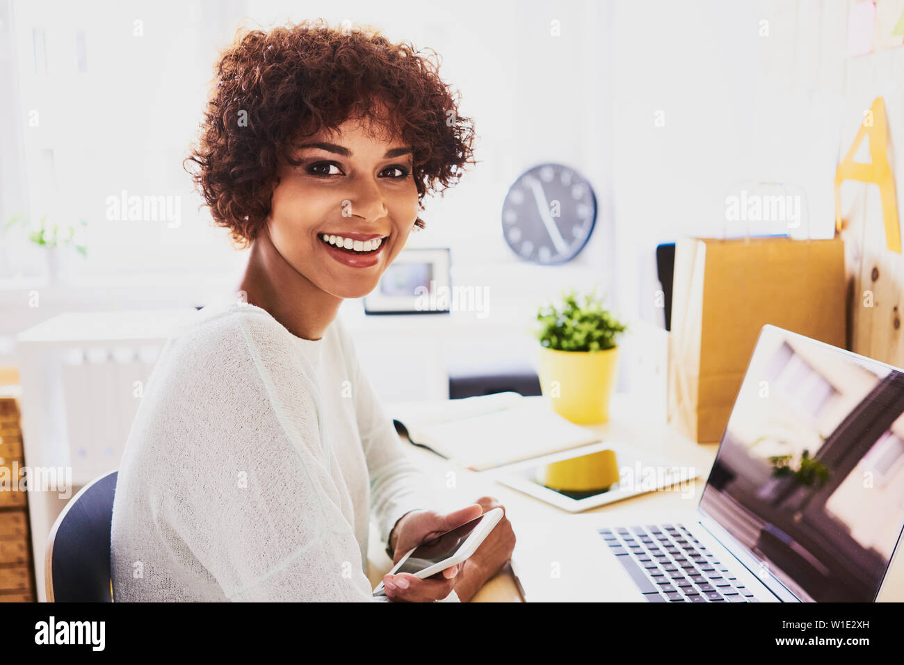 Happy african woman working from home on laptop sitting by desk Stock ...