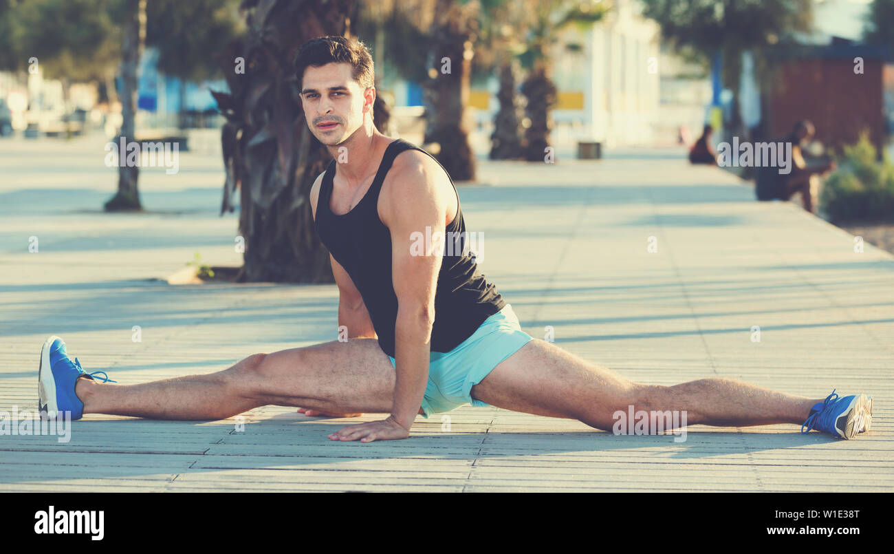 Muscular cheerful man during outdoor workout sitting on splits Stock ...