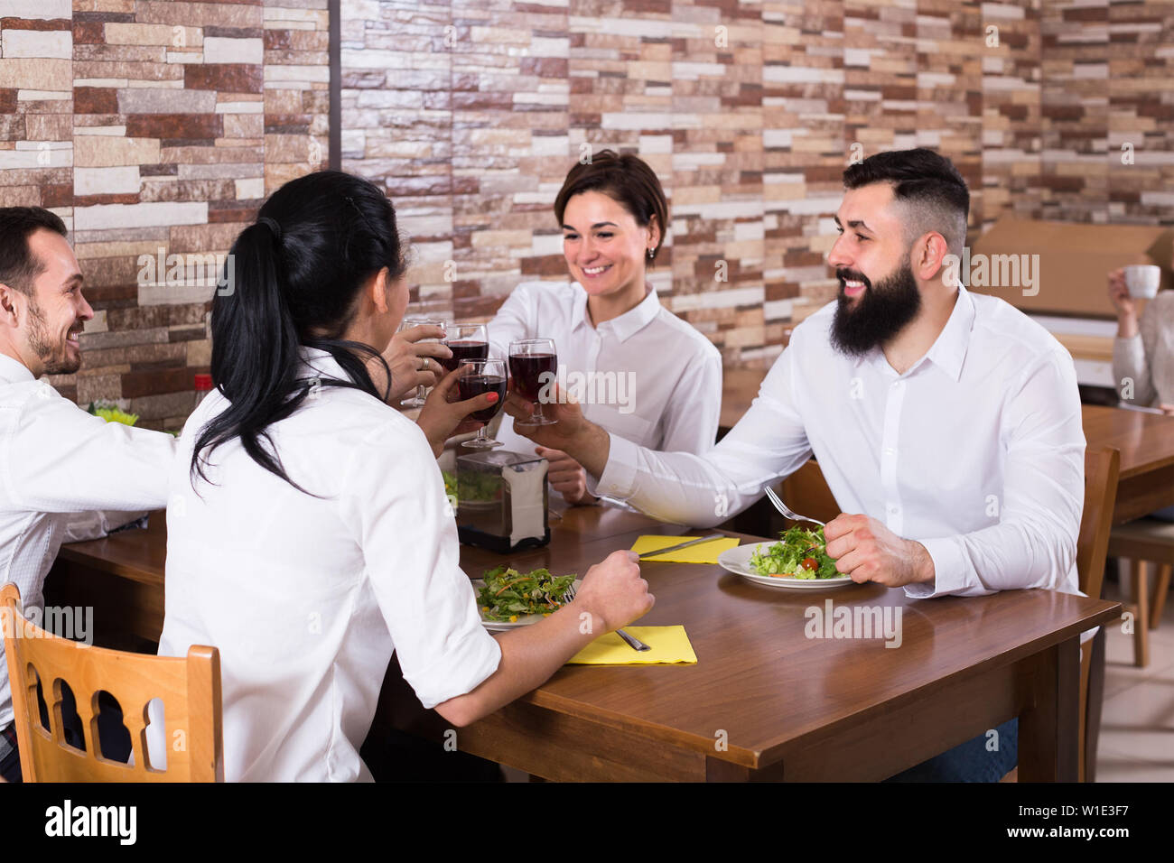 group of happy friends eating at restaurant table and chatting Stock ...