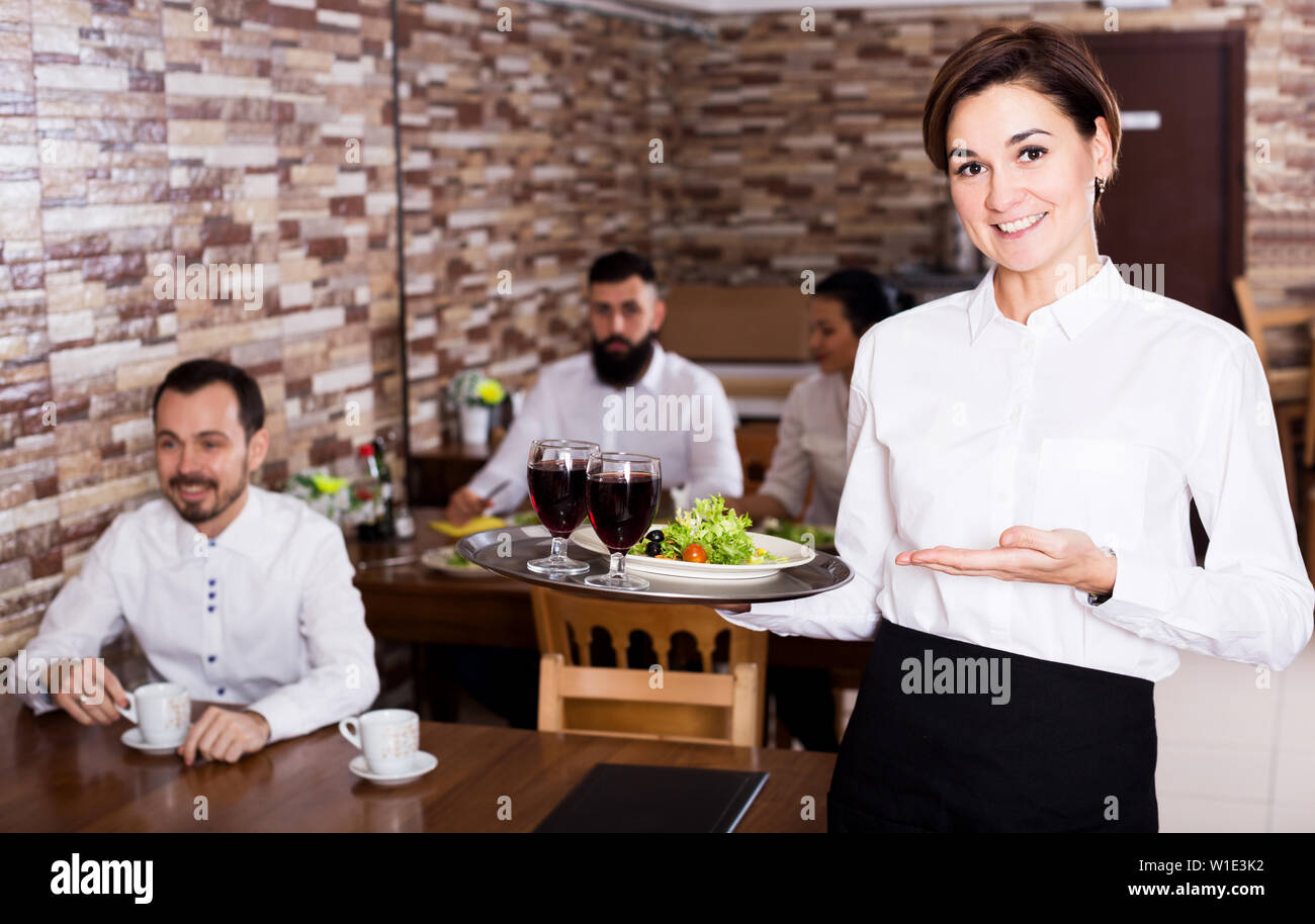 Beautiful female waiter welcoming guests to country restaurant Stock ...