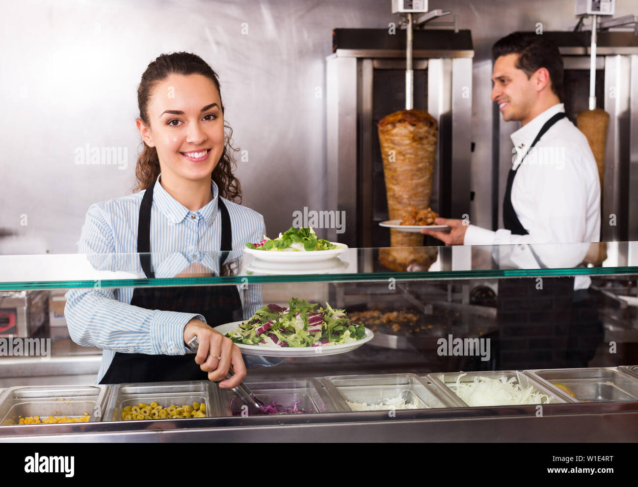 Happy adult restaurant staff posing at kebab counter and smiling Stock ...
