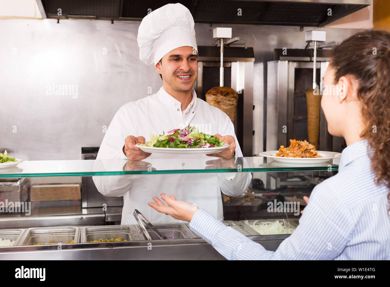 Positive staff and female client at counter of kebab cafe Stock Photo ...