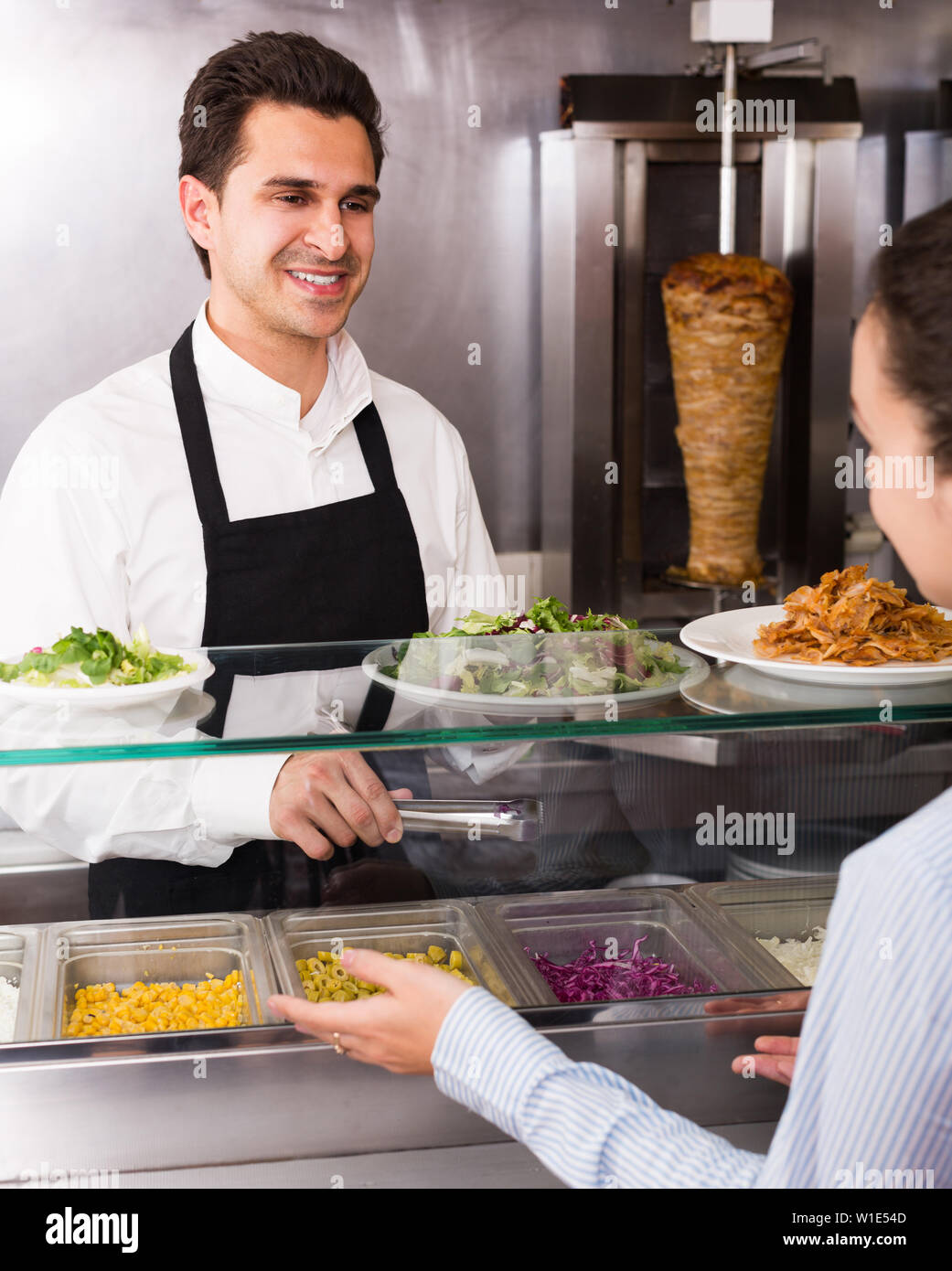Smiling staff and female client at counter of kebab cafe Stock Photo ...