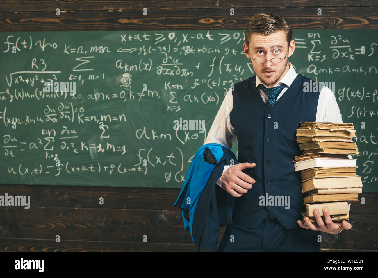 Check homework. Teacher formal wear and glasses looks smart, chalkboard ...