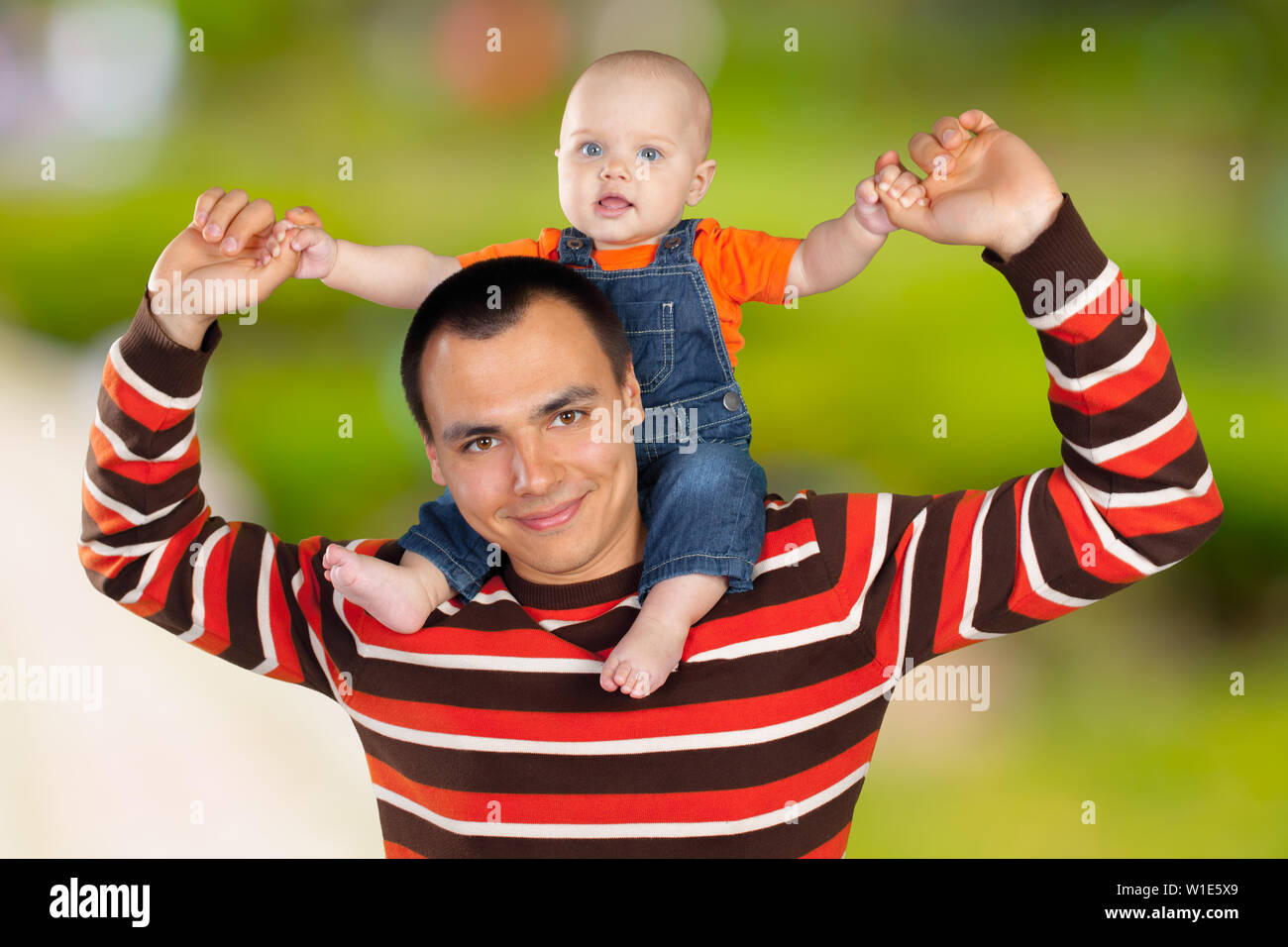 Happy young man holding a baby Stock Photo - Alamy