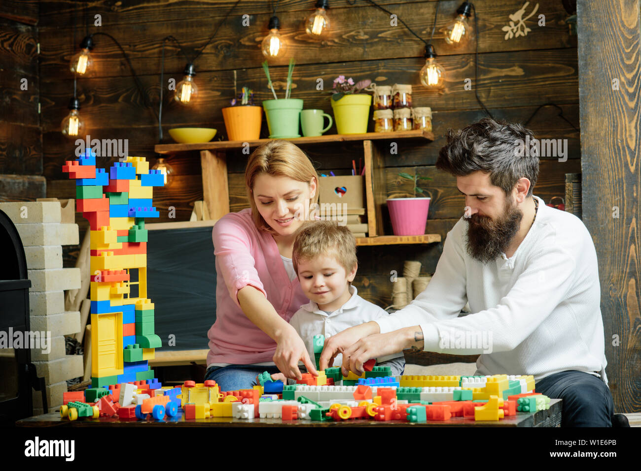 Construction concept. Little child with mother and father play with toy ...