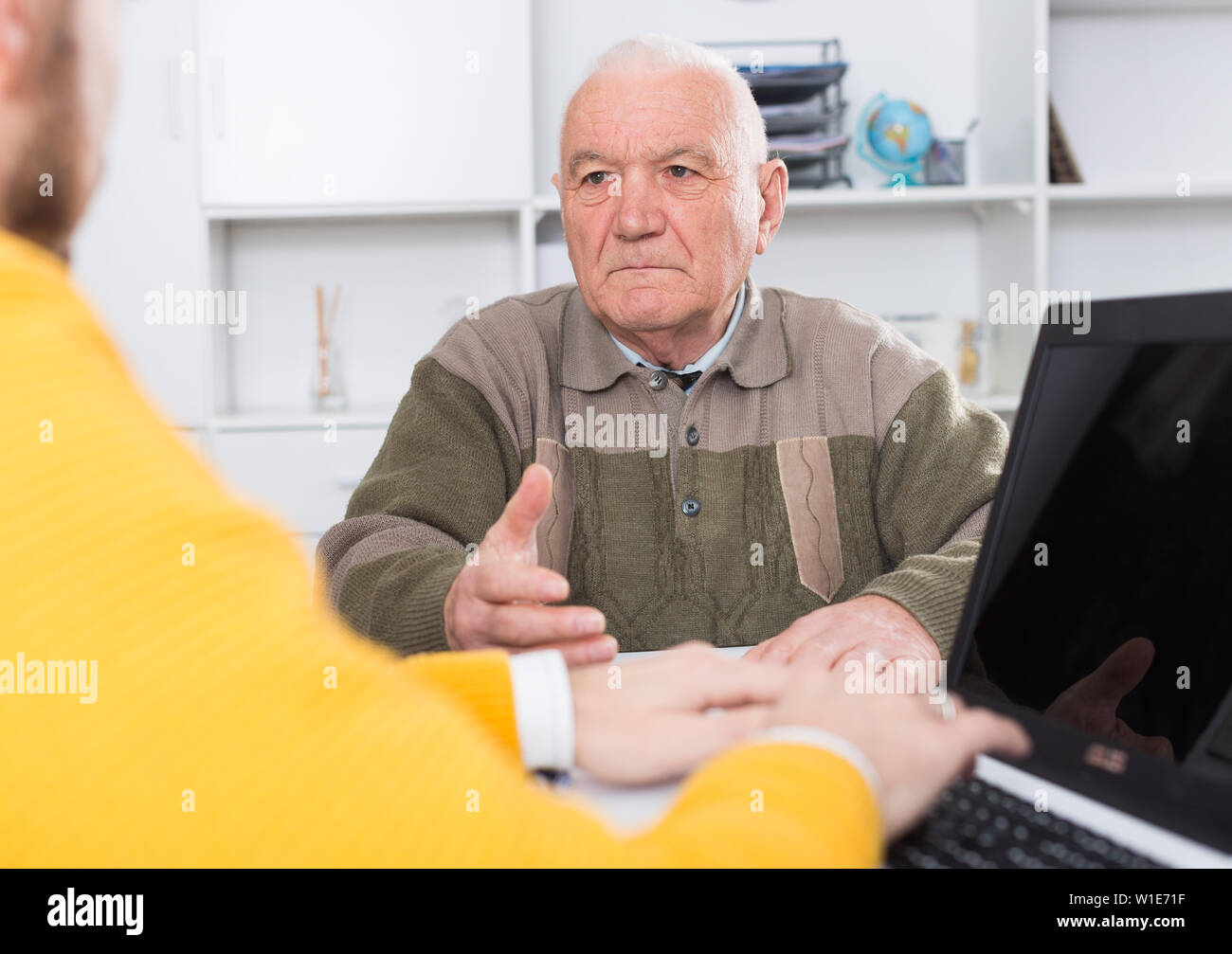 Old man and agent sign life and health insurance contract in office ...