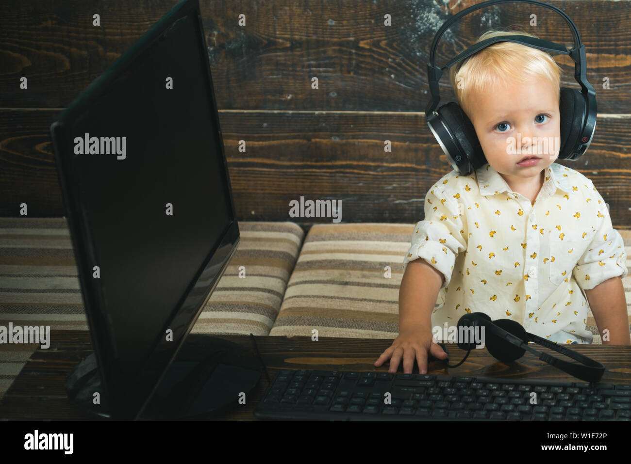 Little kid wear bluetooth headset to communicate. Boy listen headset ...