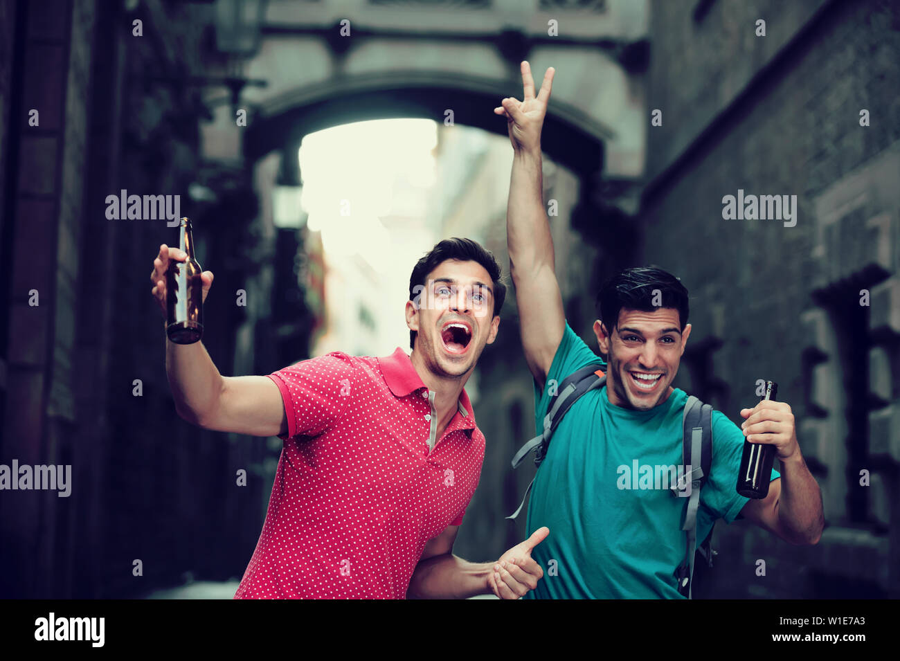 Two young men who are walking with beer in Barcelona Stock Photo - Alamy