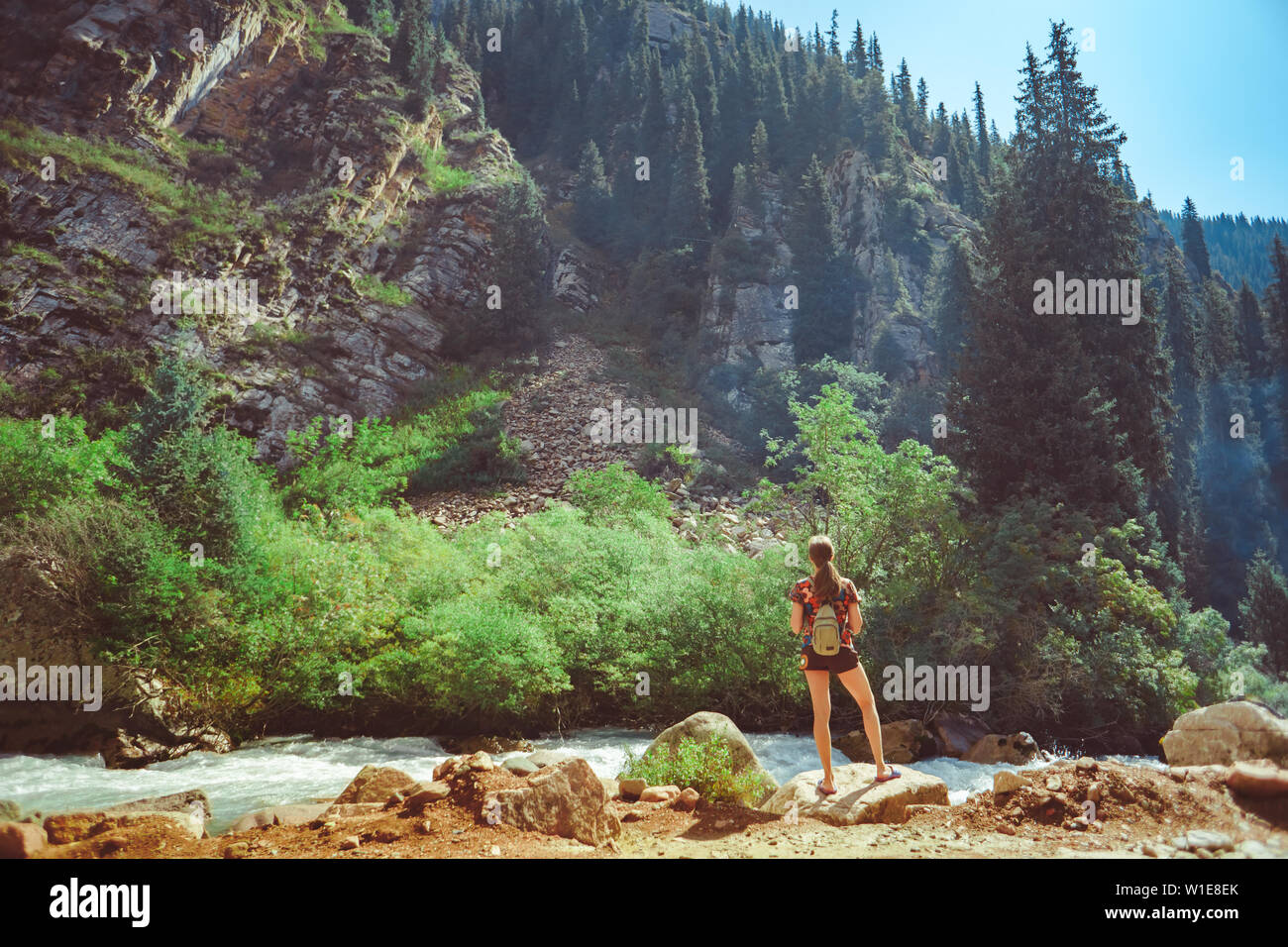 woman traveler with backpack looking at amazing mountains and river ...