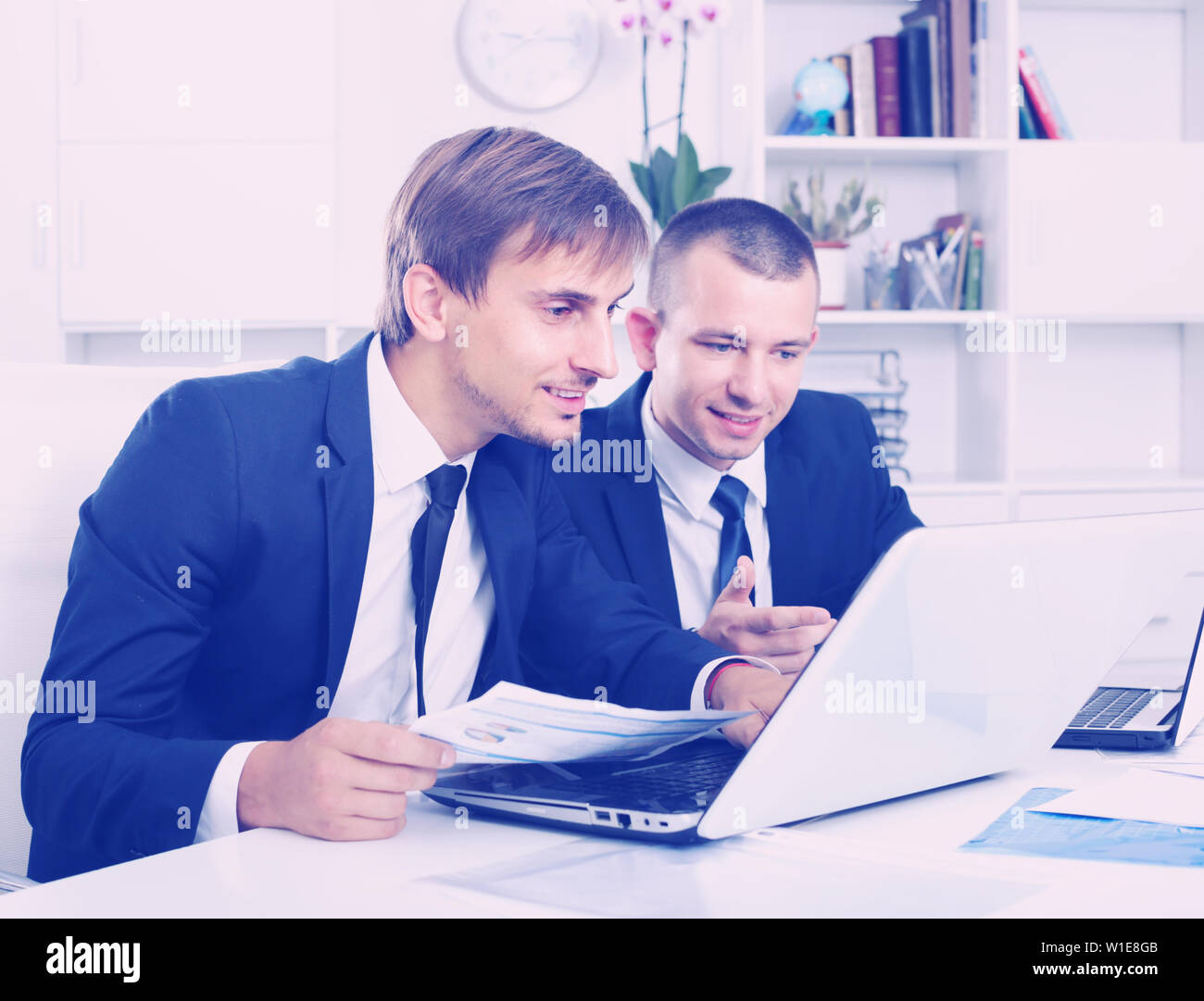 two friendly smiling business male assistants wearing formalwear ...