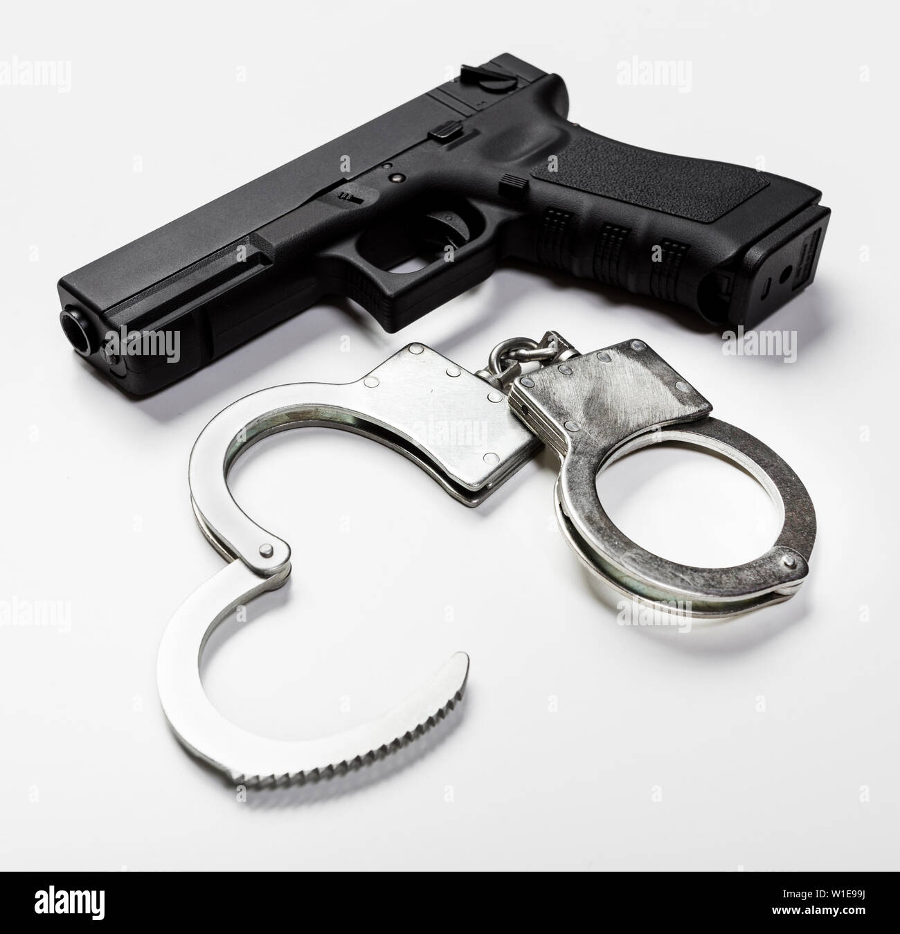gun and handcuffs on white background Stock Photo - Alamy
