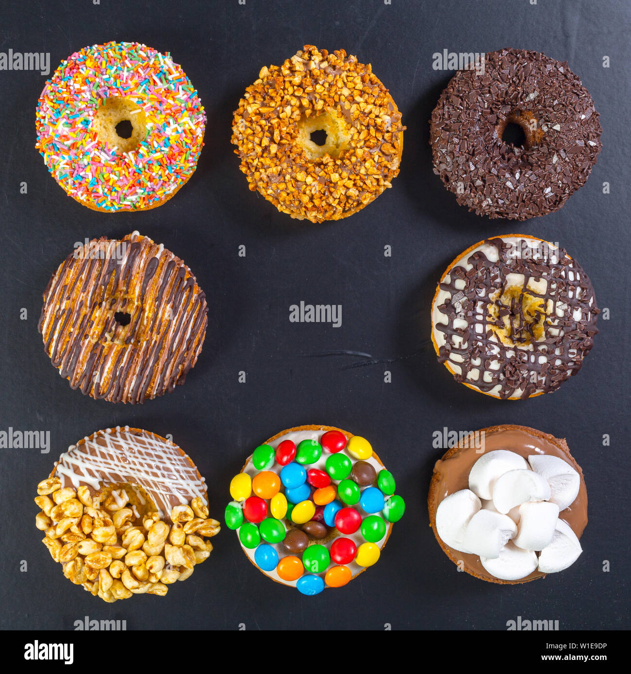 Assorted donuts from above on black background Stock Photo - Alamy