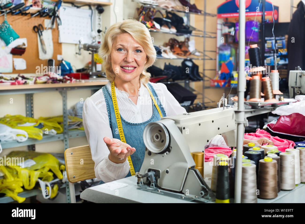 Portrait of professional female tailor working on sewing machine in ...