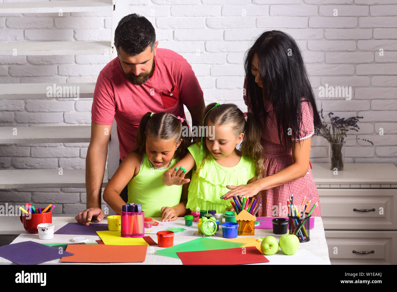 Girls drawing with mother and father. Happy childhood and parenting ...