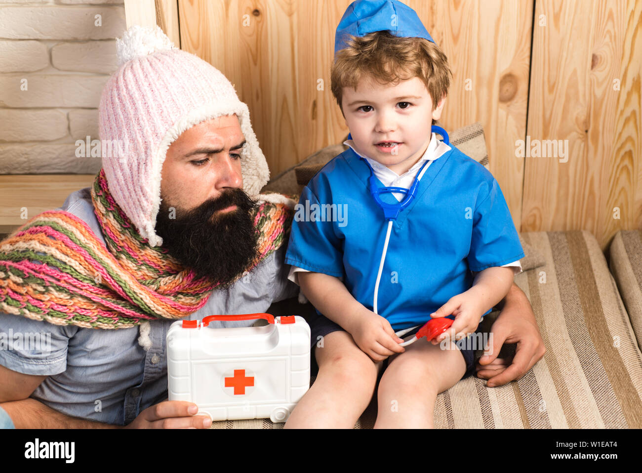 Father and son playing doctor at home. Dad and kid dressed as nurse ...