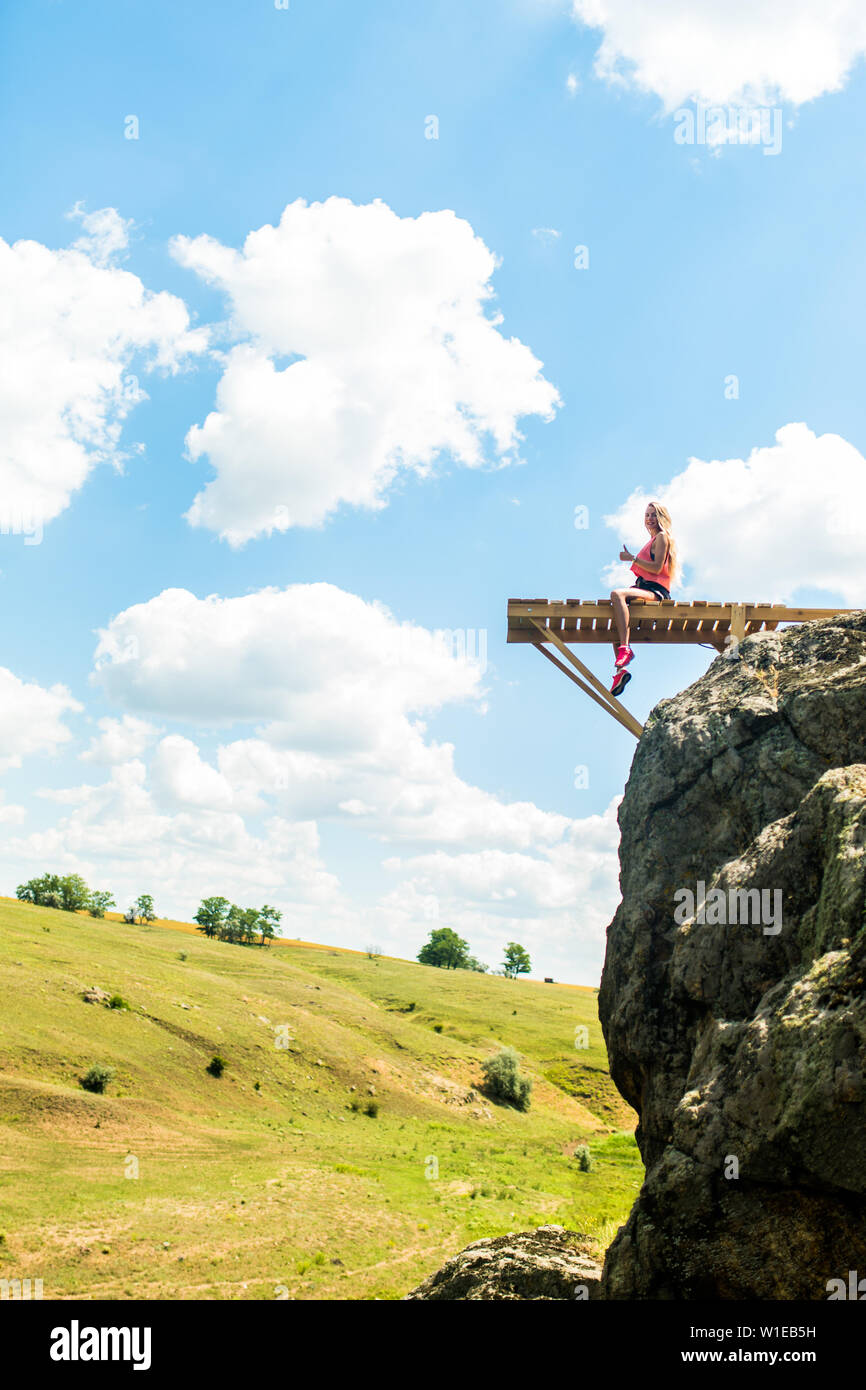 Girl sitting on rock ledge hi-res stock photography and images - Alamy