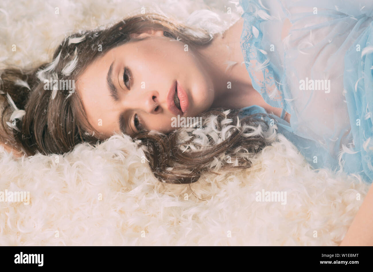 Beautiful girl drowning in soft bed. Drowsy young lady falling asleep ...