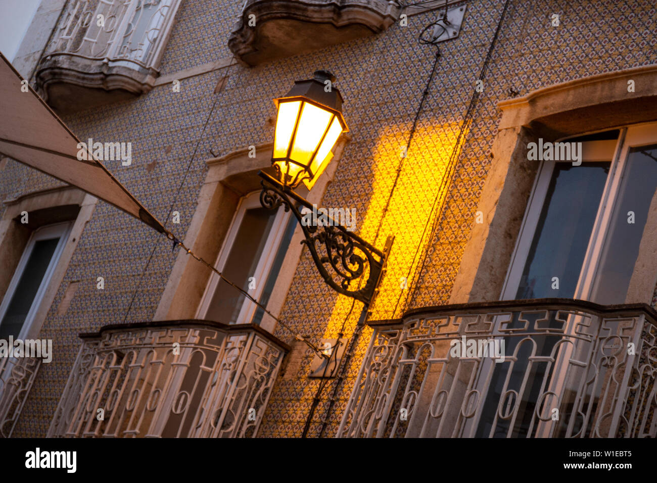 View of a lit classic European streetlight design on a vintage building ...