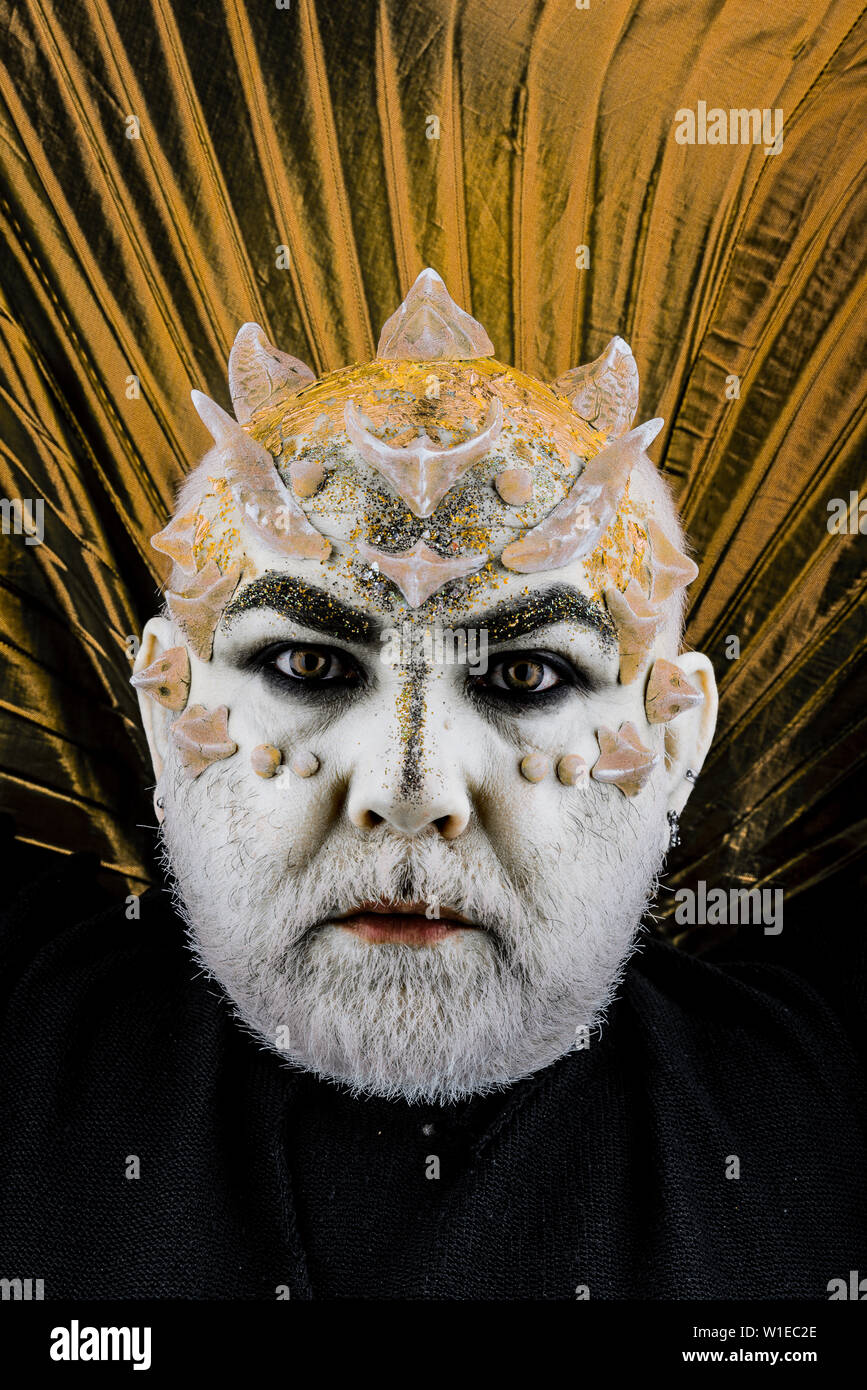 Head with thorns or warts, face covered with glitters, close up. Alien ...