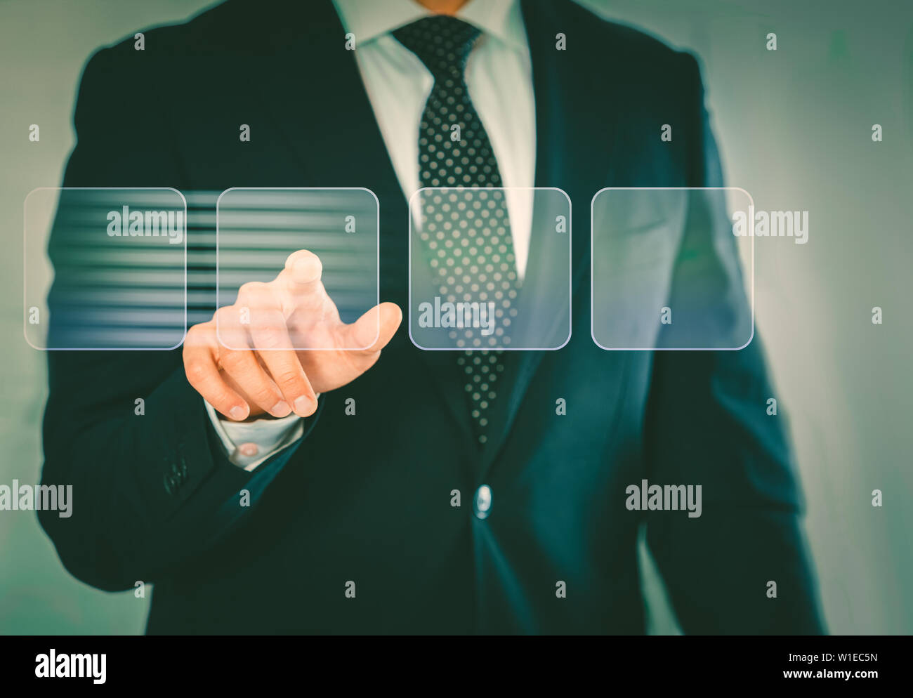Man in suit touching screen on the background of modern glass buildings ...