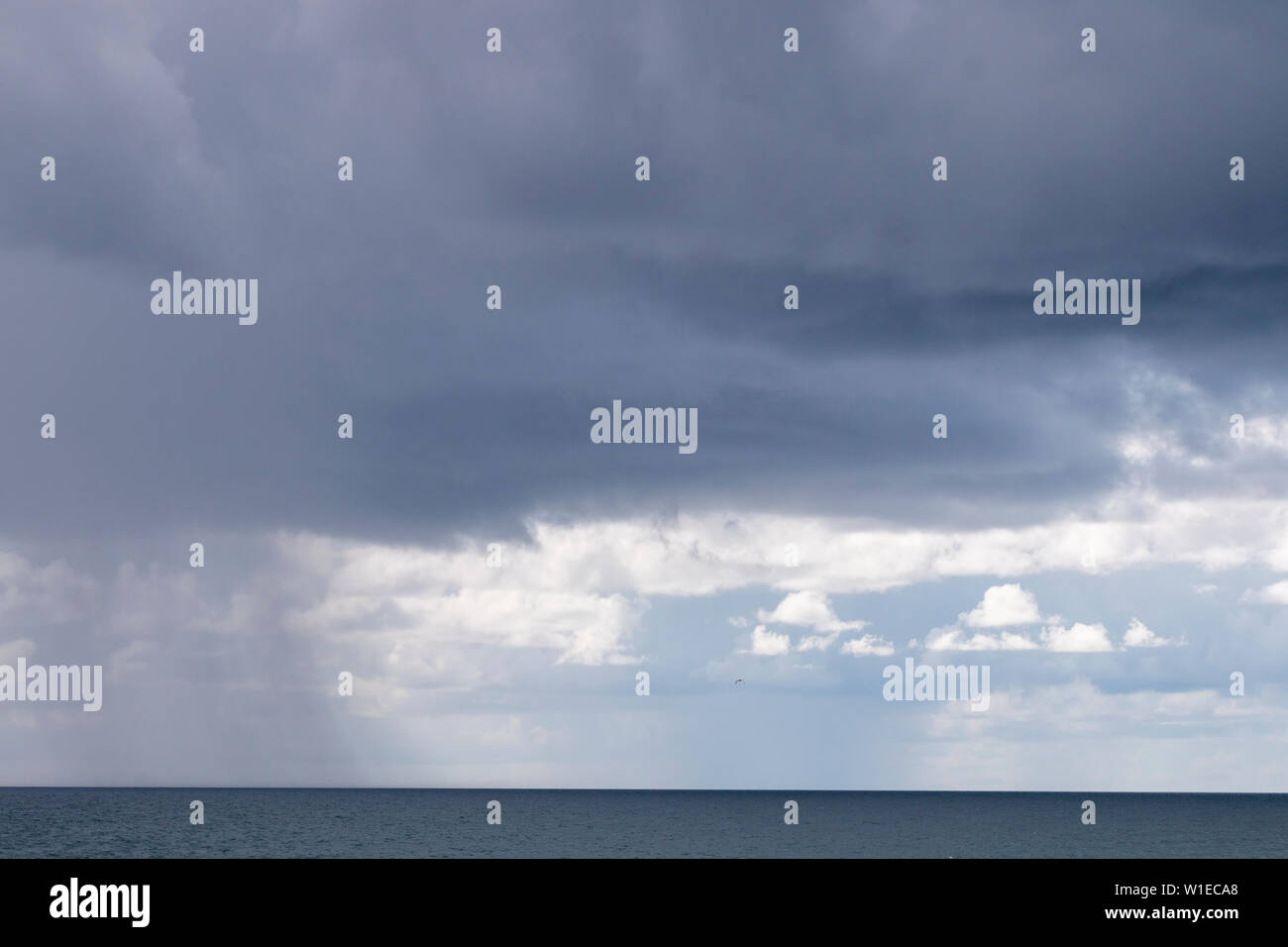 View of dark gray clouds with rain pouring from one side to the other ...