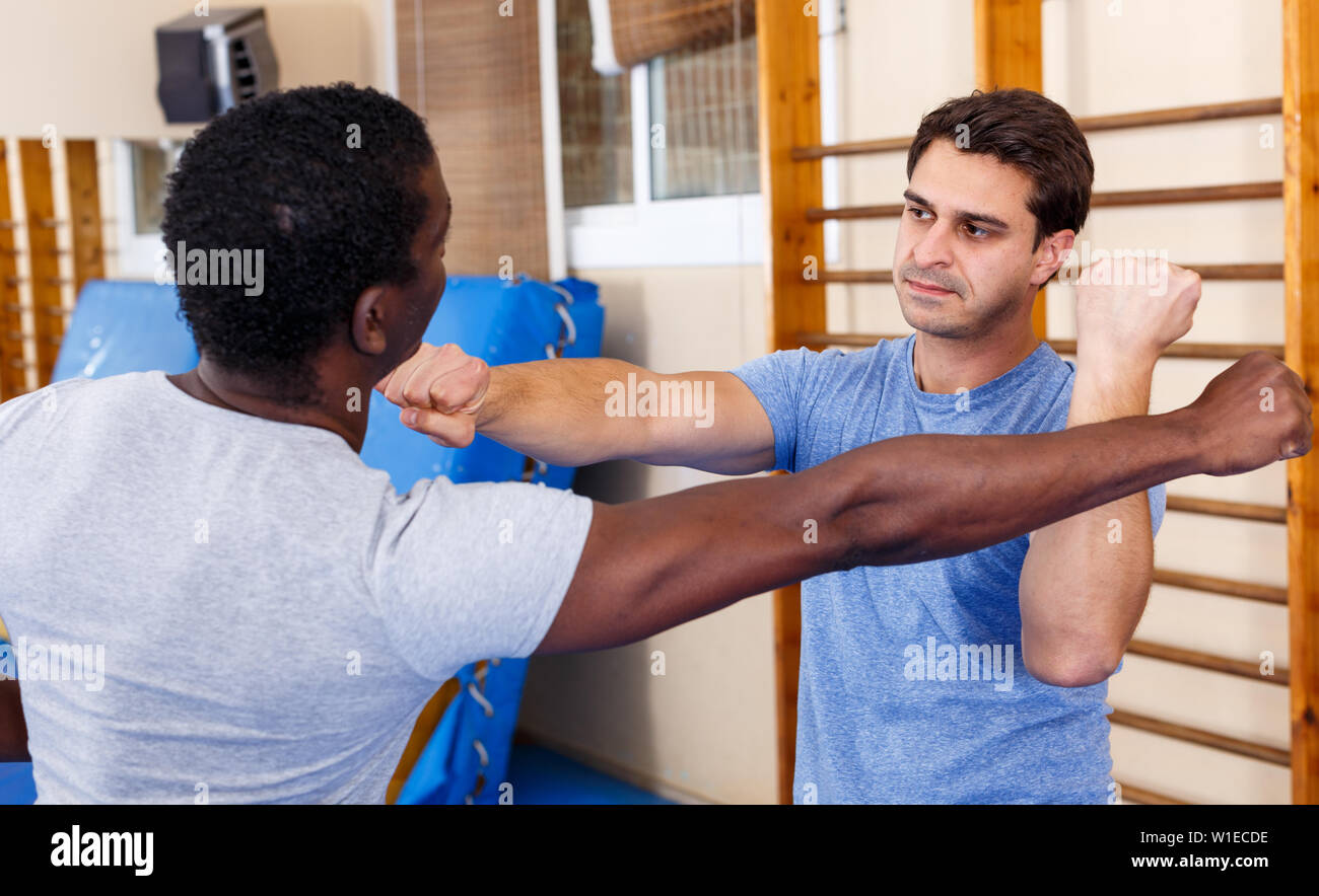Men practicing effective techniques of self-defence during individual ...