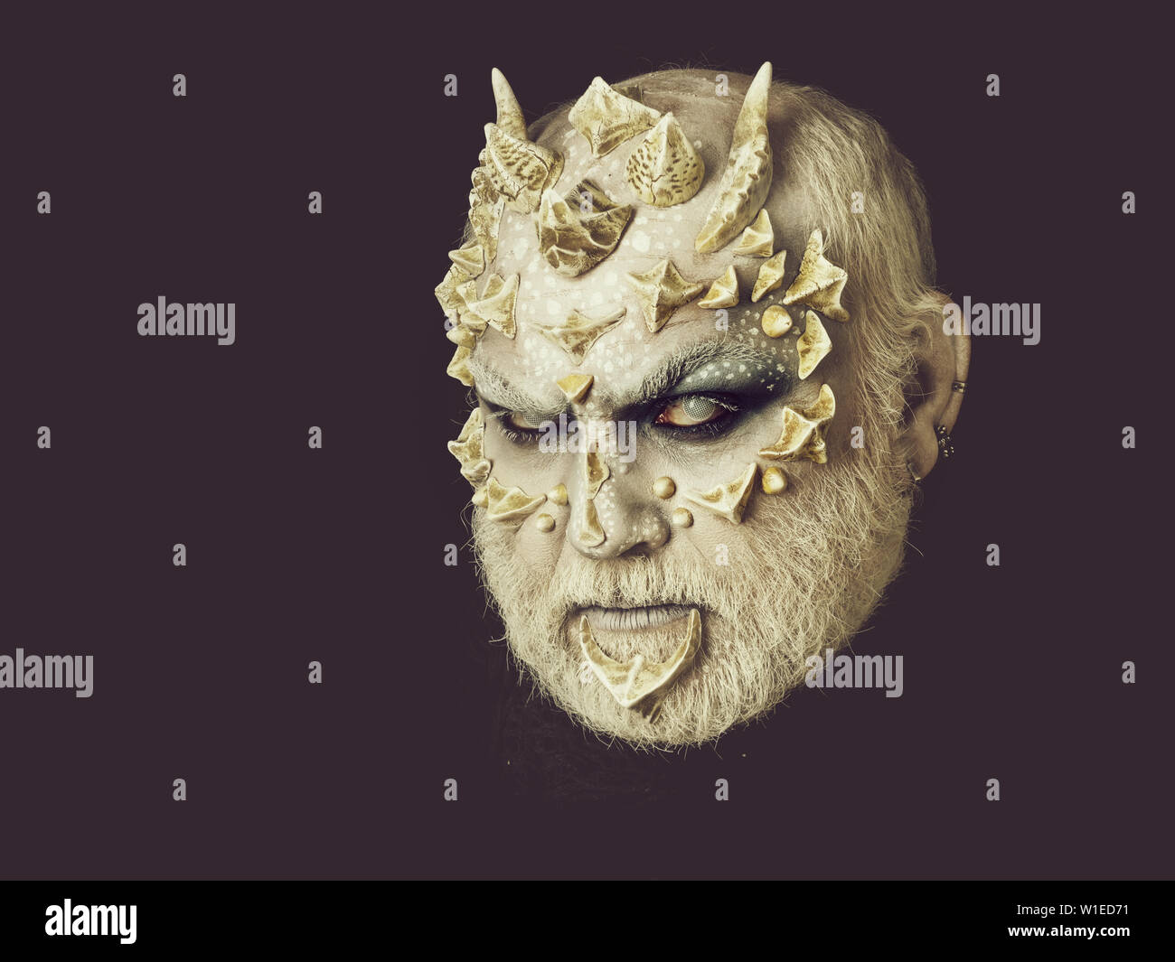 Man with dragon skin and grey beard. Monster with sharp thorns and ...